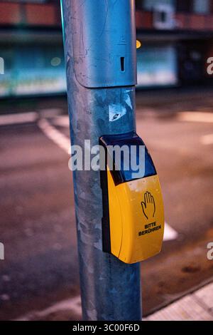 Pedestrian crossing button mounted on a metal pole beside a road Stock ...