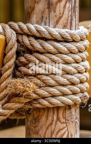 Wooden mooring post with strong rope around it Stock Photo - Alamy