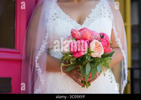 A closeup shot of bride hands with pink nail polish and a sparkly ring ...