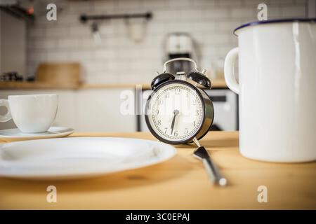 intermittent fasting concept alarm clock on kitchen table Stock Photo ...