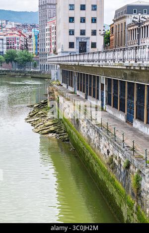 The waterfront in the historic center of Bilbao with green trees and ...