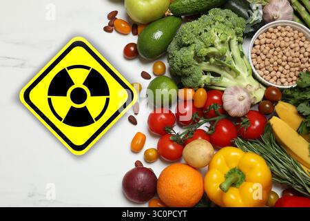 Fresh vegetables and radioactive sign on white background ...