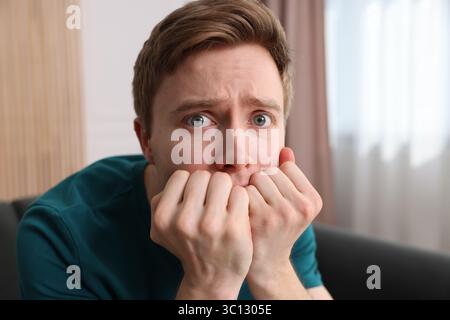 Scared man suffering from paranoia at home Stock Photo - Alamy