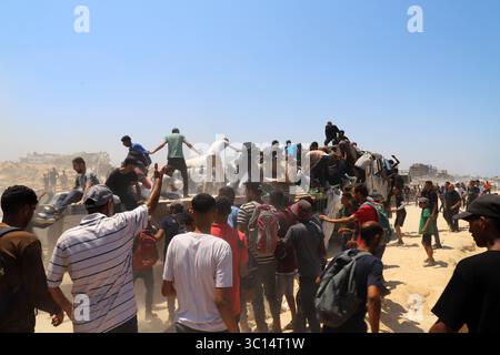 People make their way along al-Rashid street in western Jabalia People ...