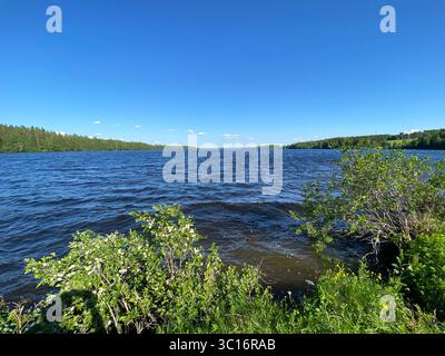 beautiful clear lake surrounded by greenery with mountains in ...