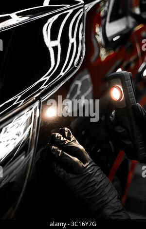 Swirl finder light to detect paint issues on black car in a detailing ...