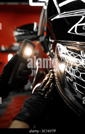 Swirl finder light to detect paint issues on black car in a detailing ...