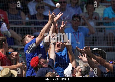 Fans in the stands reach for a foul ball during the second inning of a ...
