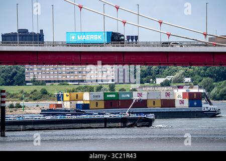 A cargo ship is sailing upstream on the Rhine near Duisburg, followed ...
