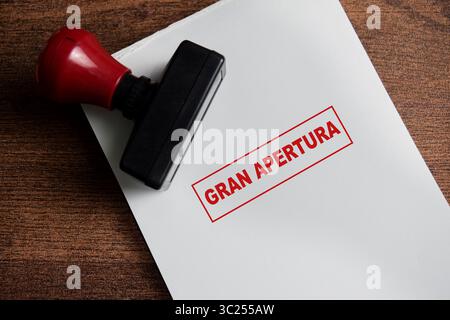 Red Handle Rubber Stamper and Grand opening in spanish text above book ...