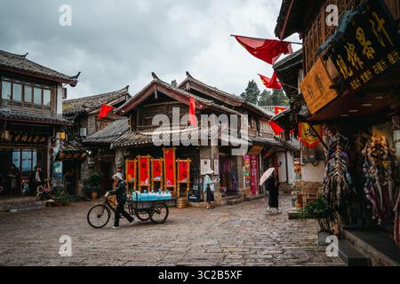 Small shopping cart with chinese flag on the table. Man using laptop ...