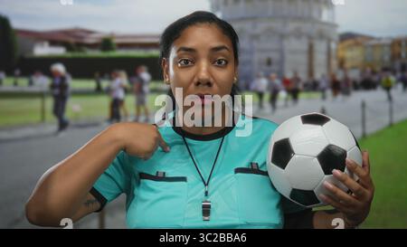 Smiling referee woman wearing turquoise jersey holds soccer ball by ...