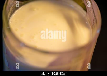 A clean, high-resolution photo of creamy white kefir being poured into ...
