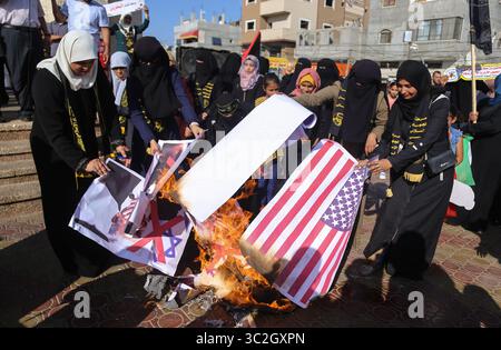 Palestinian women burn placards depicting U.S. President Donald Trump ...