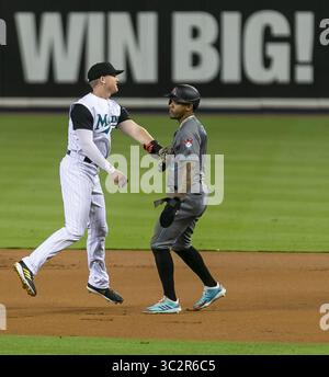 Miami Marlins' Garrett Cooper, left, high-fives before a baseball game ...