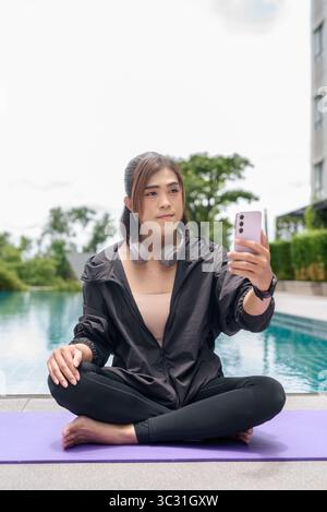 Transgender woman performing yoga poses outdoors by pool, showcasing ...