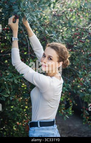Beautiful woman farmer enjoying a summer day, holding bowl with ...