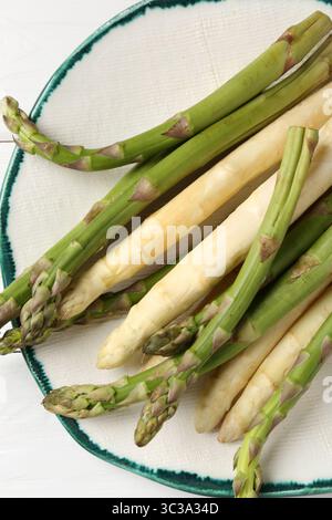 Different raw asparagus spears on white wooden table, top view. Space ...