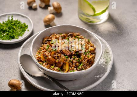 Cooked buckwheat in a bowl, garnished with fresh parsley, on a purple ...