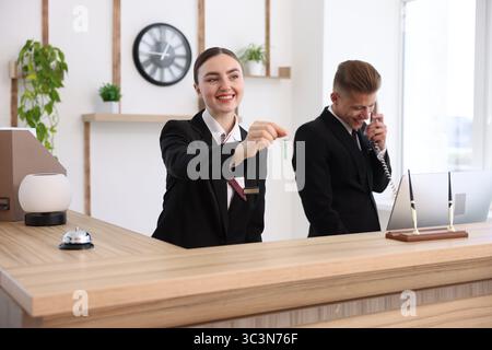 Smiling receptionists working at reception desk in hotel Stock Photo ...