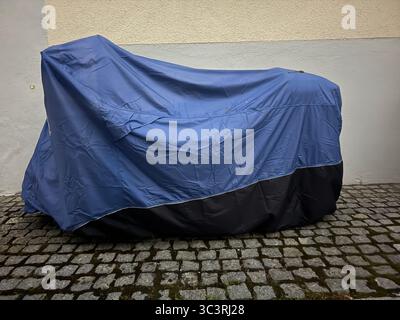 Blue and black motorcycle cover is draped over a motorcycle Stock Photo ...
