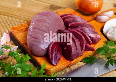 Sliced raw pork kidney with garlic and greens during cooking Stock ...