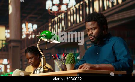 Black university student highlighting relevant phrases to learn the ...