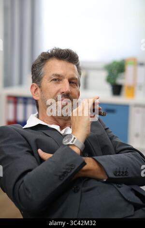 Man in office smoking with cigarette and feet on the table Stock Photo ...
