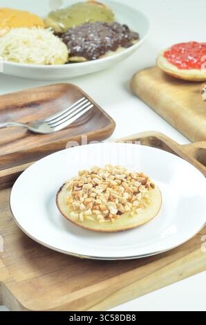 Serabi pancake with peanut topping and condensed milk, a traditional ...