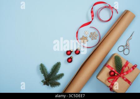 Festive packaging. Box with bauble, scissors, wrapping paper and ...