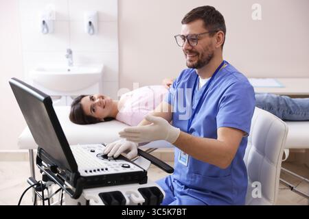 Sonographer showing woman her ultrasound imaging on screen in clinic ...