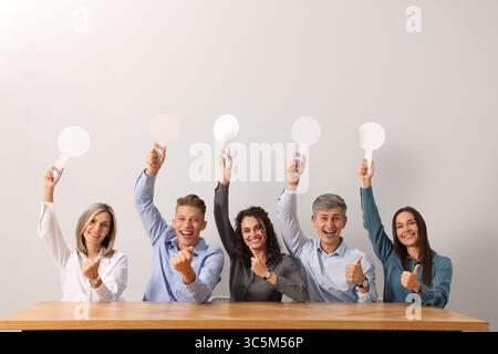 Panel of emotional judges voting with score signs at table against ...