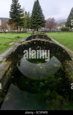 Old Roman stone arches forming ancient water fountains in a landscaped ...
