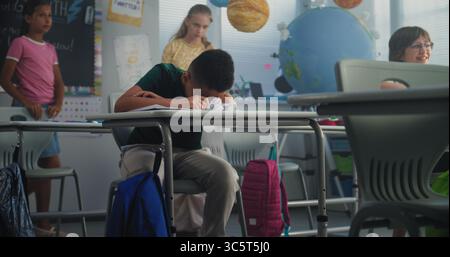 african american boy sitting alone by school lockers, feeling upset and ...