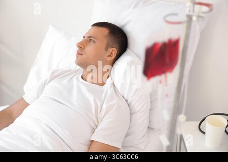 Male patient transfusing blood on bed in hospital ward Stock Photo - Alamy