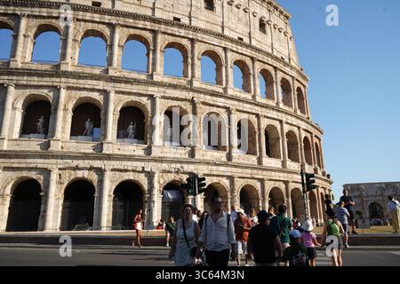 People walk past the ancient Colosseum as they take part in the Pride ...