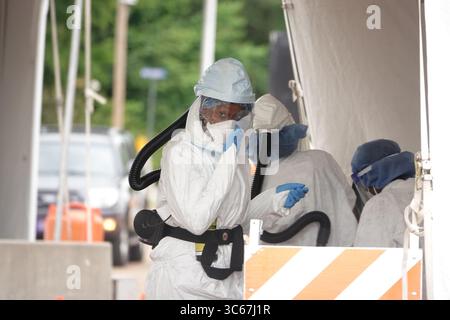 A healthcare worker cleans a coronavirus testing isolation booth at a ...