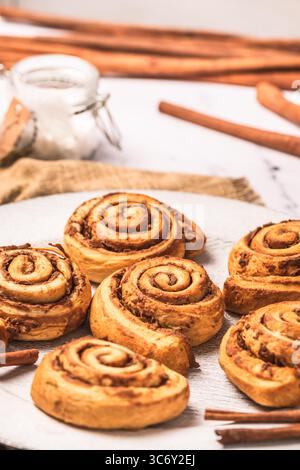 Cinnamon rolls on a white plate with an orange - peach background Stock ...