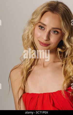Beautiful blonde woman displays her trendy denim outfit against a warm ...