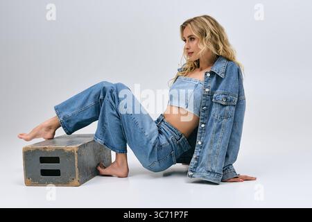 A beautiful blonde woman elegantly showcases her trendy denim fashion ...