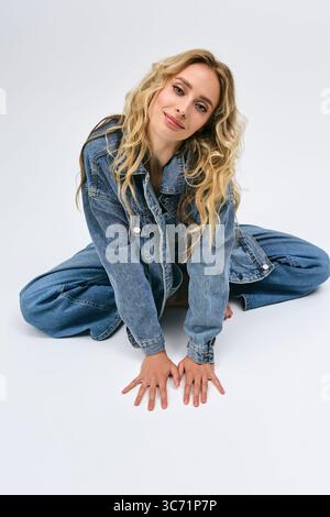 Confident blonde woman showcases her unique denim outfit with a trendy ...