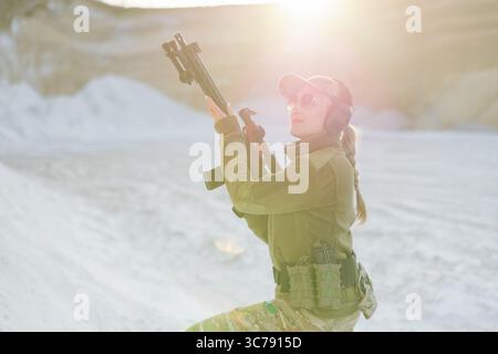 Female soldier reloading her rifle during a winter military training ...