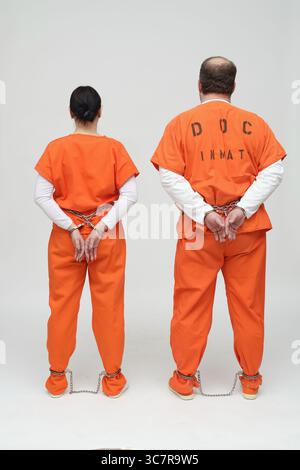2 prisoners in handcuffs with belly chain and orange overalls Stock ...