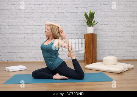 woman doing mermaid pose at yoga studio Stock Photo - Alamy