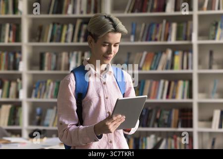 Smiling asian male student in eyeglasses talking by smartphone and ...