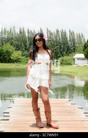 Young woman tourist wearing summer hat listening to music at street ...