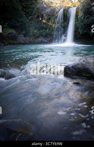 A vertical shot of a beautiful waterfall in a rocky forest Stock Photo ...