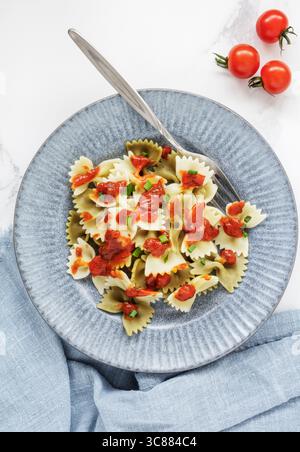 Cooked farfalle or bow tie pasta on a plate on white background Stock ...