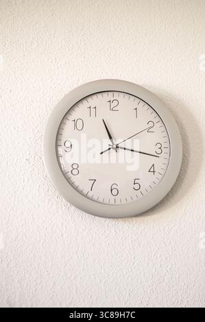 Modern wall clock on a white wall in a bright minimalist interior ...