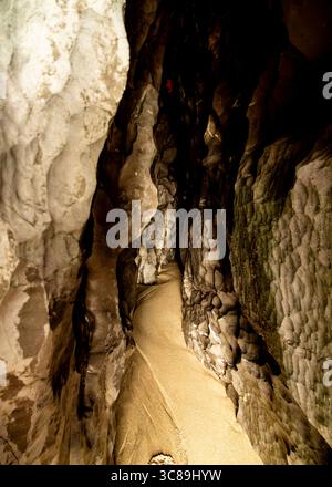 Dark Cave Entrance With Path Leading To Light Stock Photo - Alamy